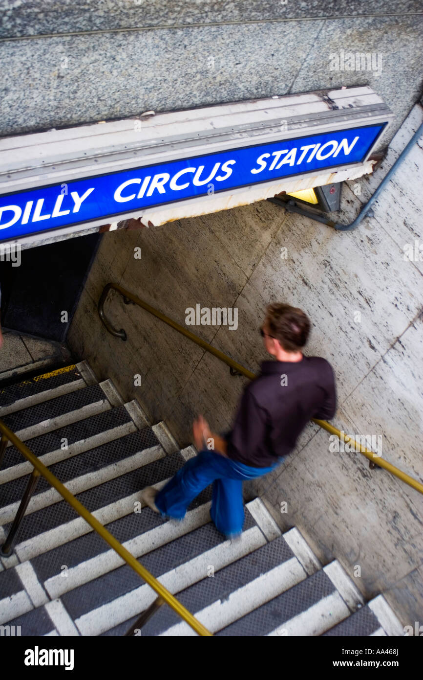 a man rushing down the stairs to london's undergroung picadilly circus ...