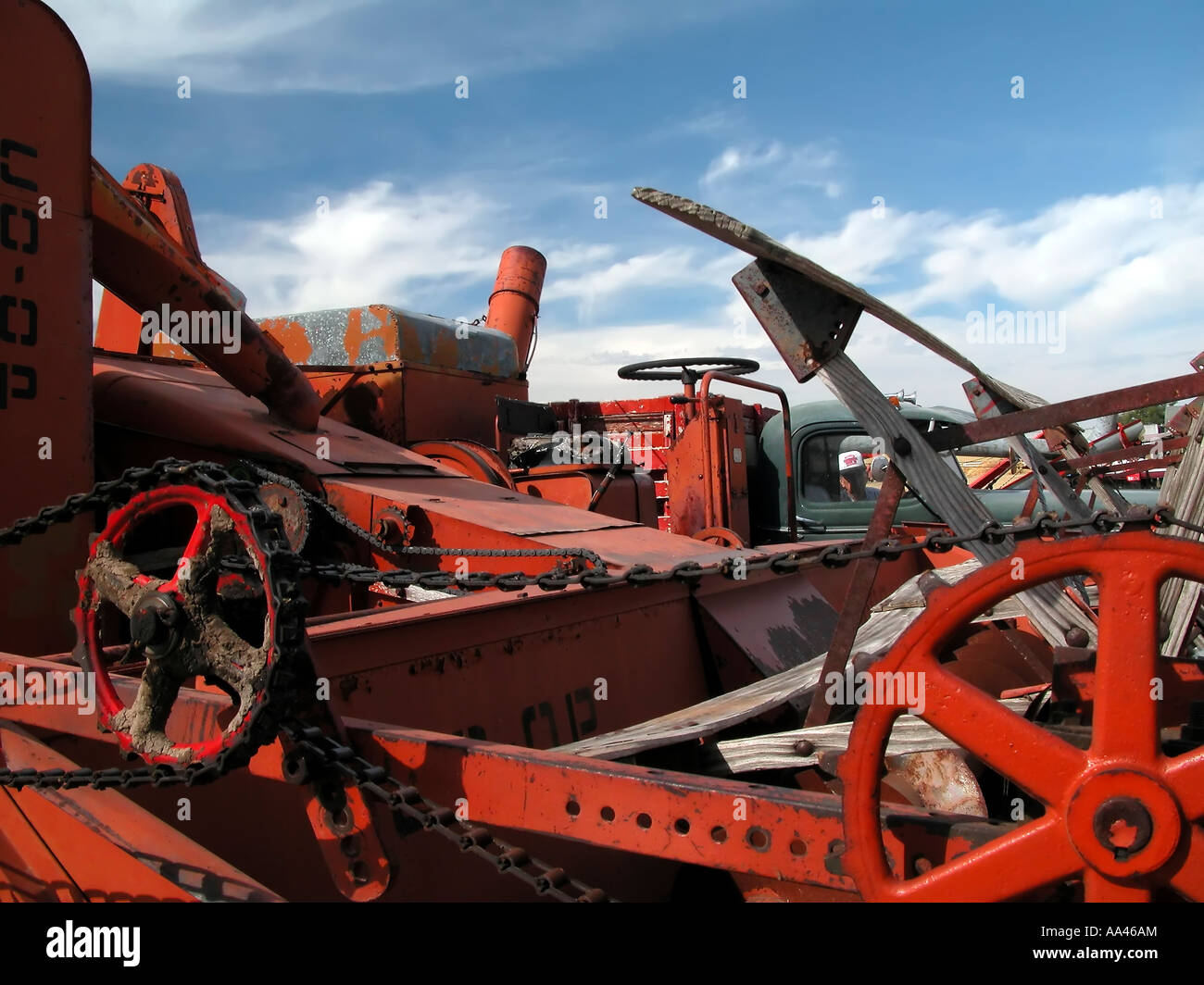Orange CO OP Combine Thresher with exposed chains and wooden paddles at ...