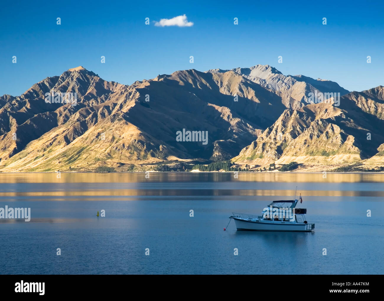 A boat moored on a New Zealand lake as the sun sets Stock Photo - Alamy