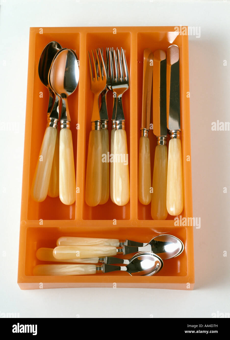 Orange storage box with cutlery with white handles Stock Photo - Alamy