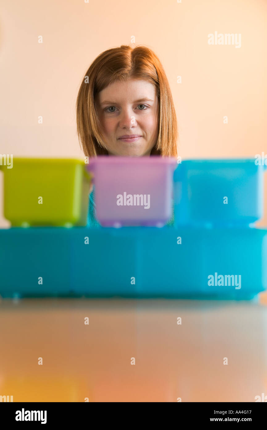Woman sitting behind colourful storage boxes Stock Photo - Alamy