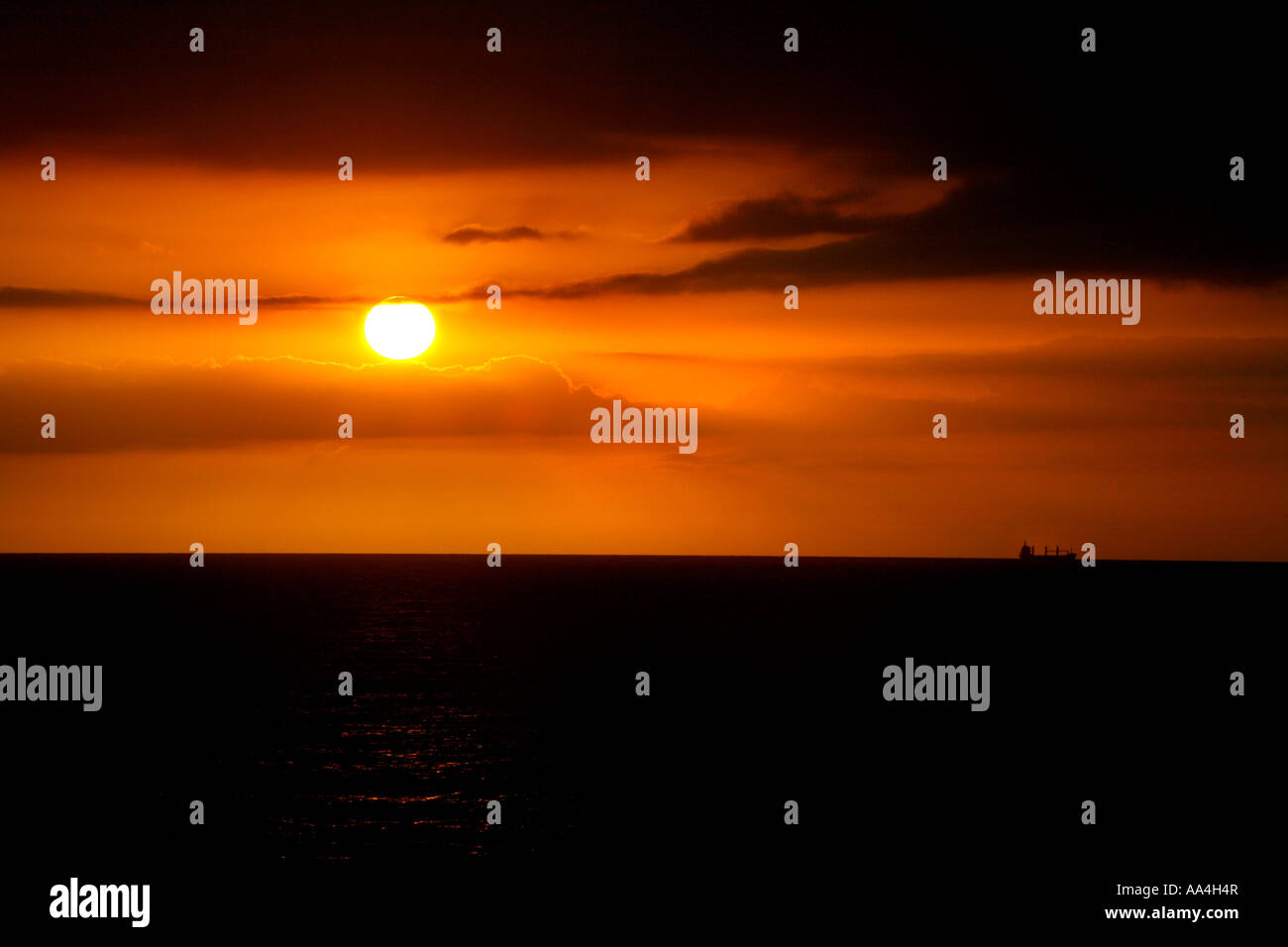 A small ship on the horizon at sunrise off the coast of NSW Australia ...