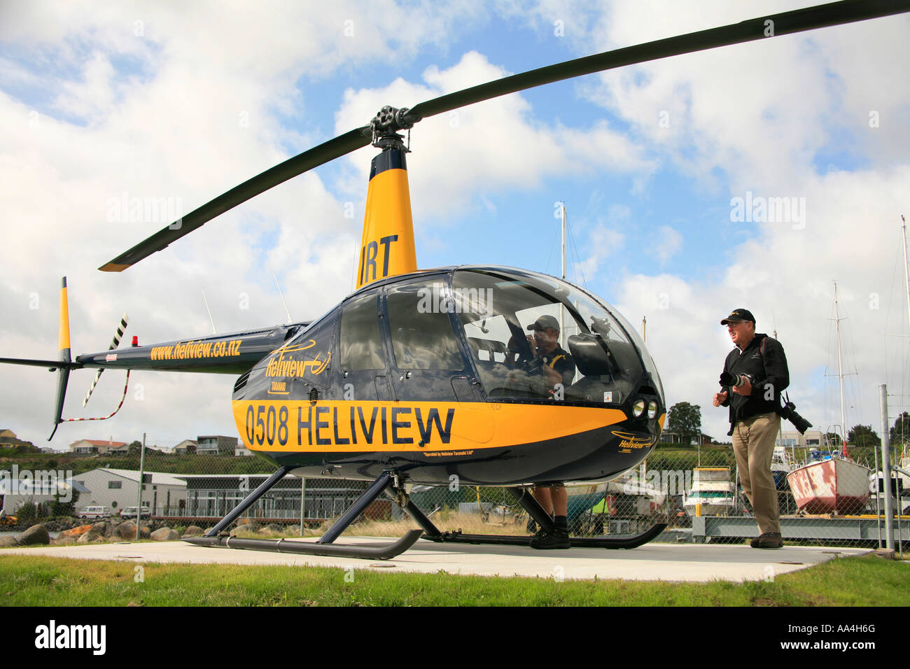 A photographer waits whilst a chopper pilot removes the door from a ...