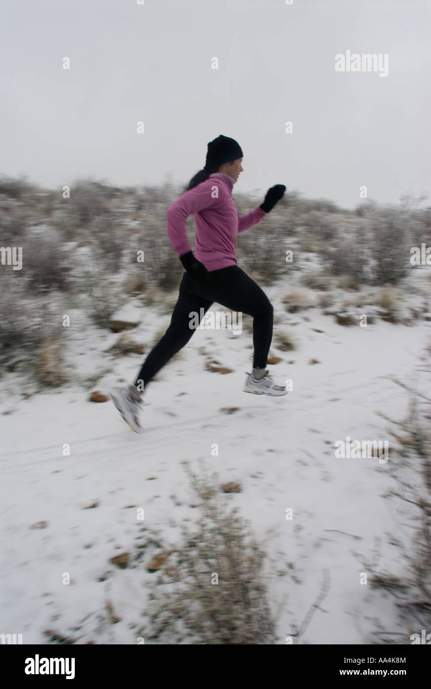 Woman trail running in the snow Stock Photo - Alamy