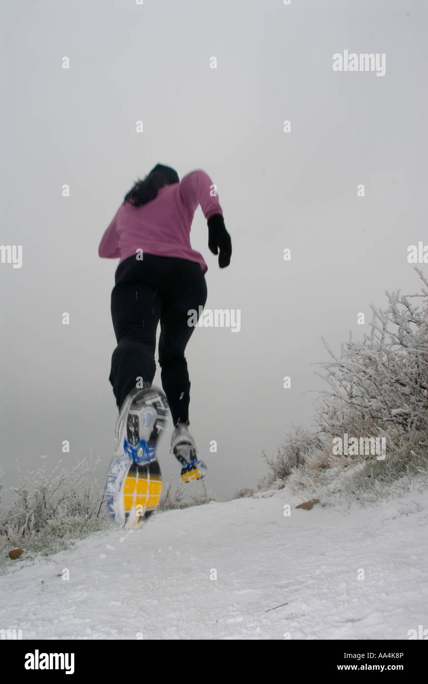 Woman trail running in the snow Stock Photo - Alamy