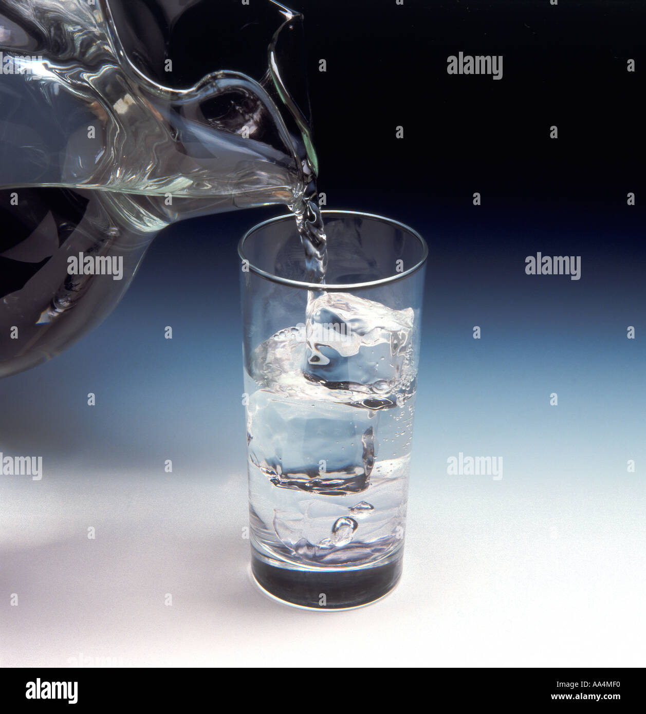 Water pouring from a pitcher into a glass of ice Stock Photo - Alamy