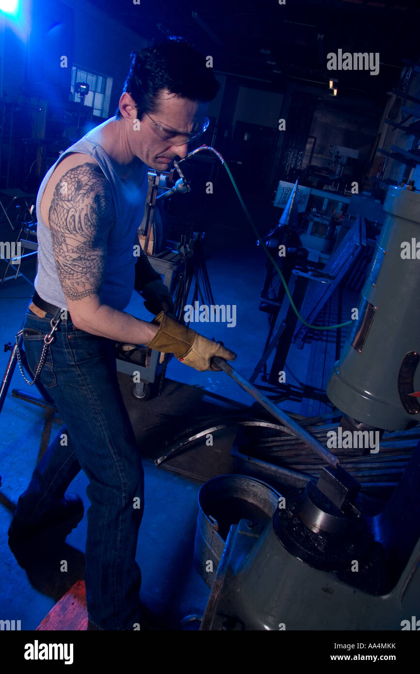 Blacksmith shaping metal into form using a power hammer Stock Photo - Alamy