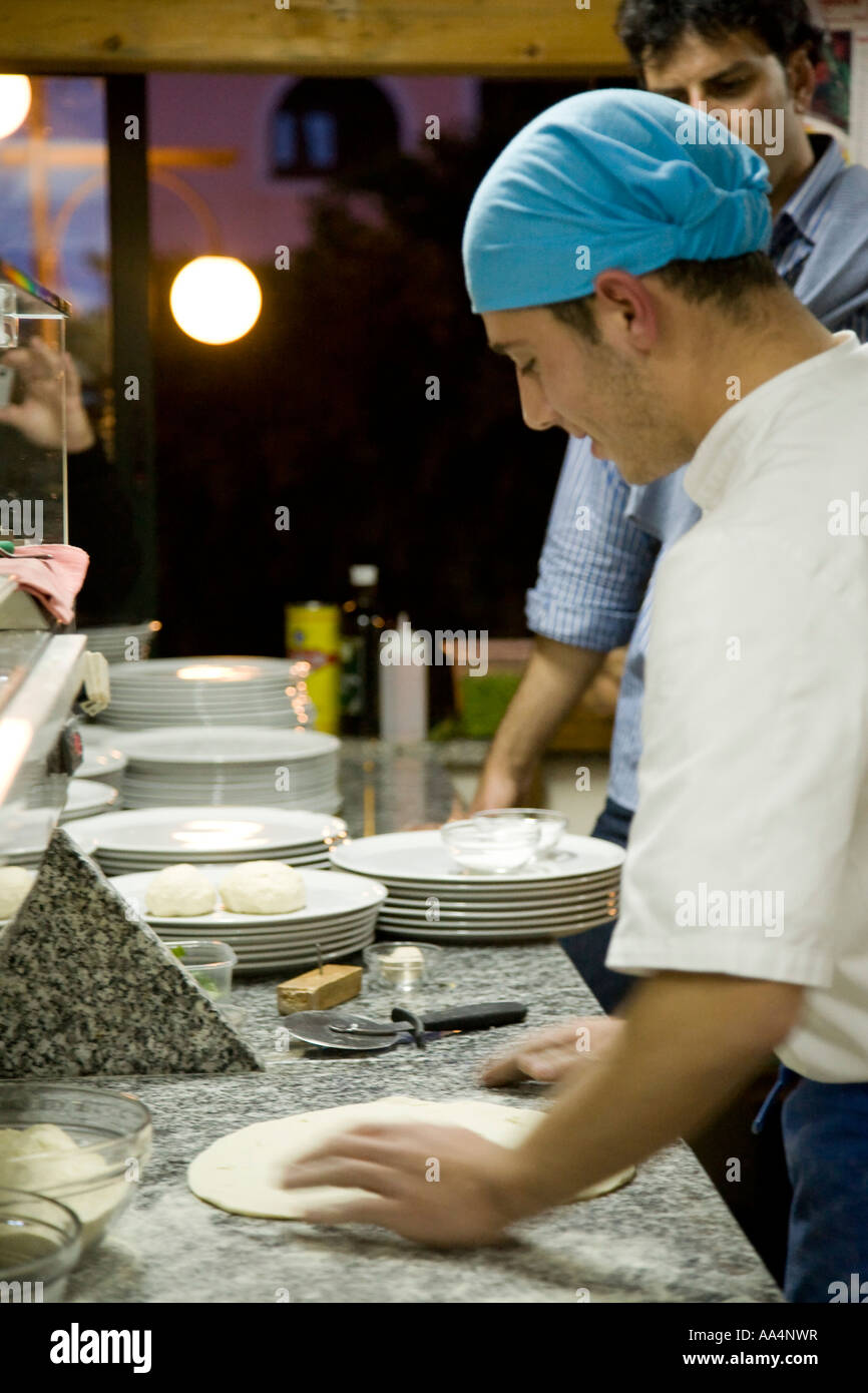 Pizza chef demonstrating art of making pizza dough on marble counter ...