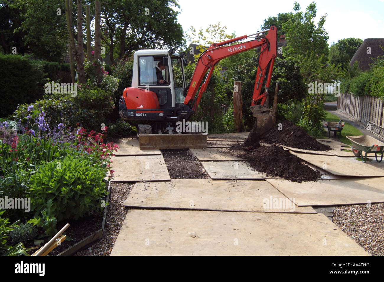 Mechanical digger working in a country garden Hampshire England UK ...