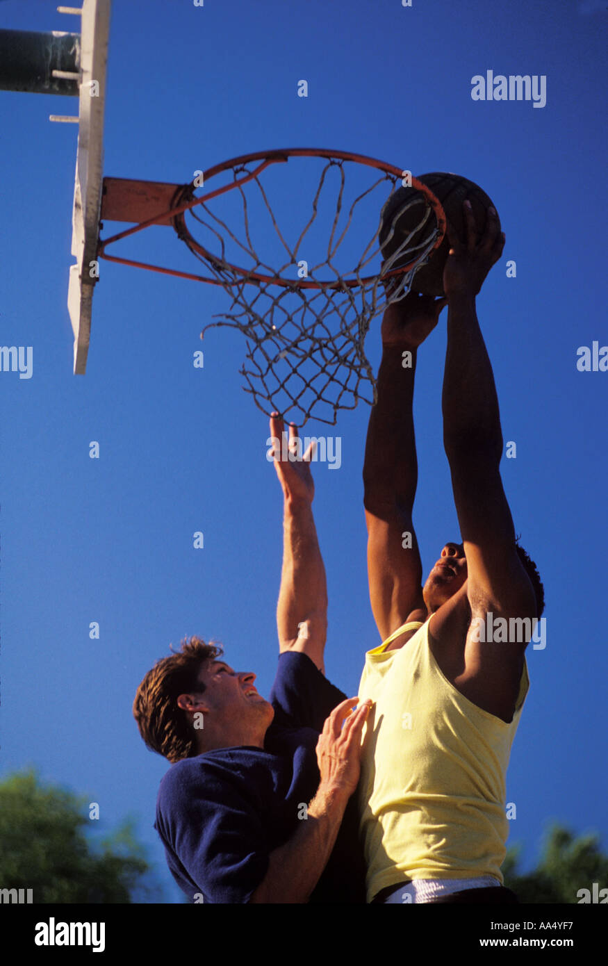 A player attempts to dunk the basketball over his opponent Stock Photo ...
