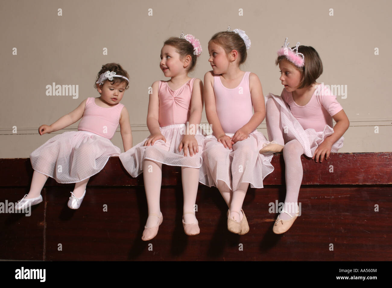 4 small girls sat on stage during a ballet session Stock Photo - Alamy