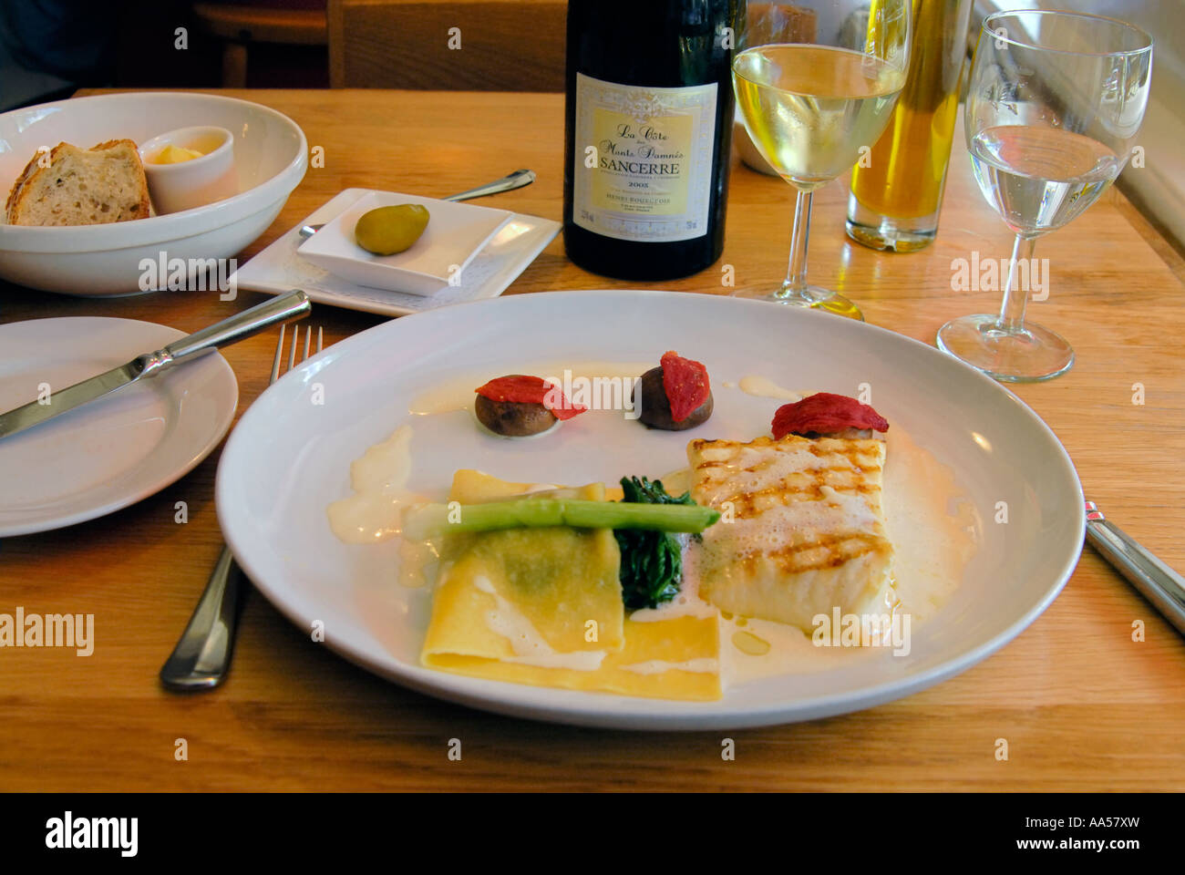 A haddock fish dish with white wine, bread and butter Stock Photo - Alamy