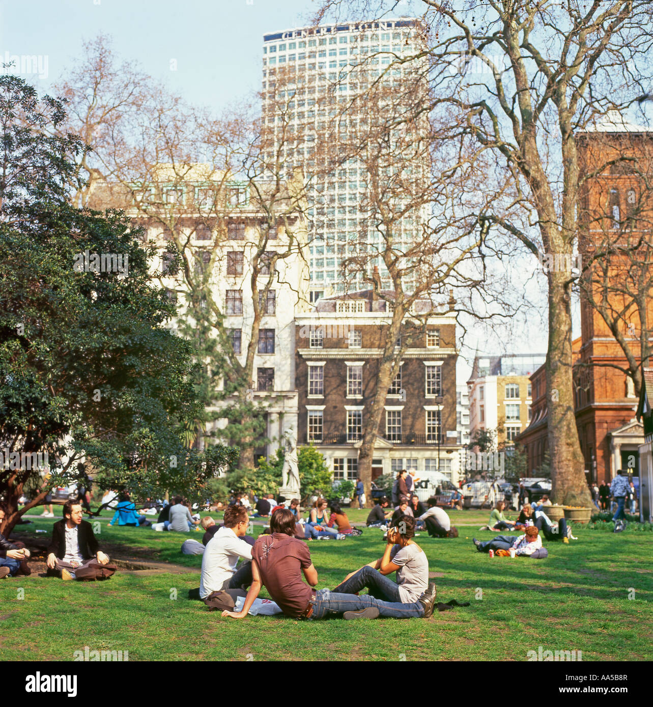 Office workers relaxing in Soho Square at lunchtime with Centrepoint in ...