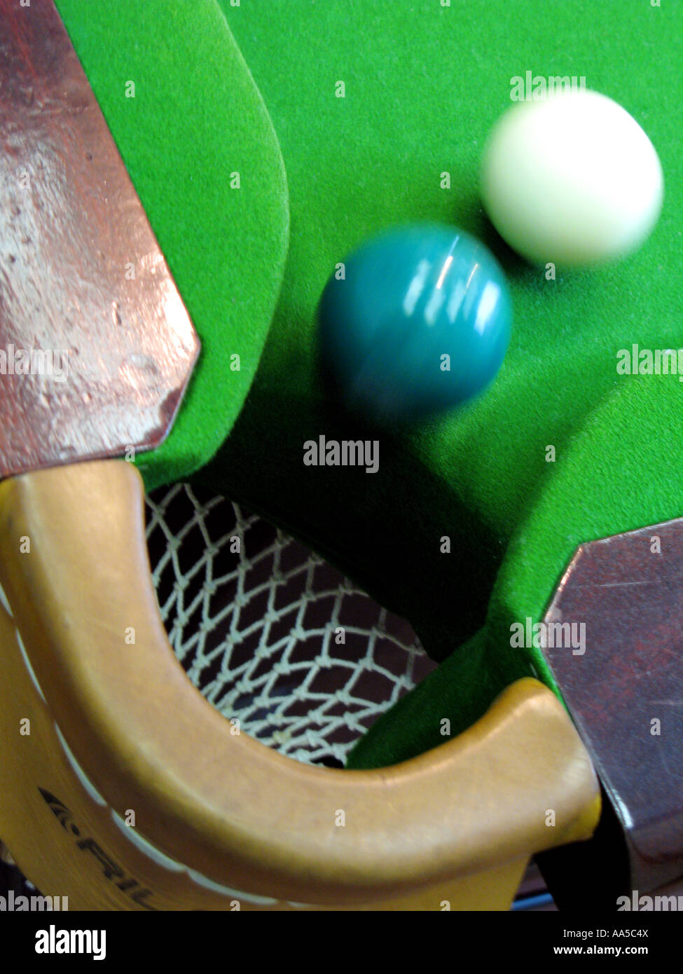 White ball pushing the green ball into a pocket on a snooker table ...