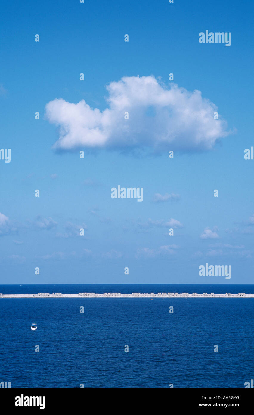 Blue sky ocean with fishing boat and the old sea harbour wall ...