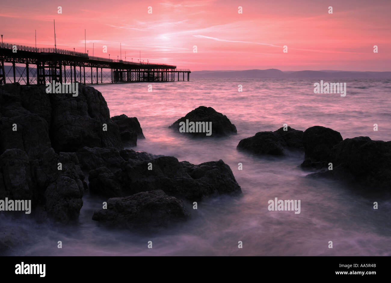 Mumbles Pier and beach at sunrise with atmospheric moody lighting and ...