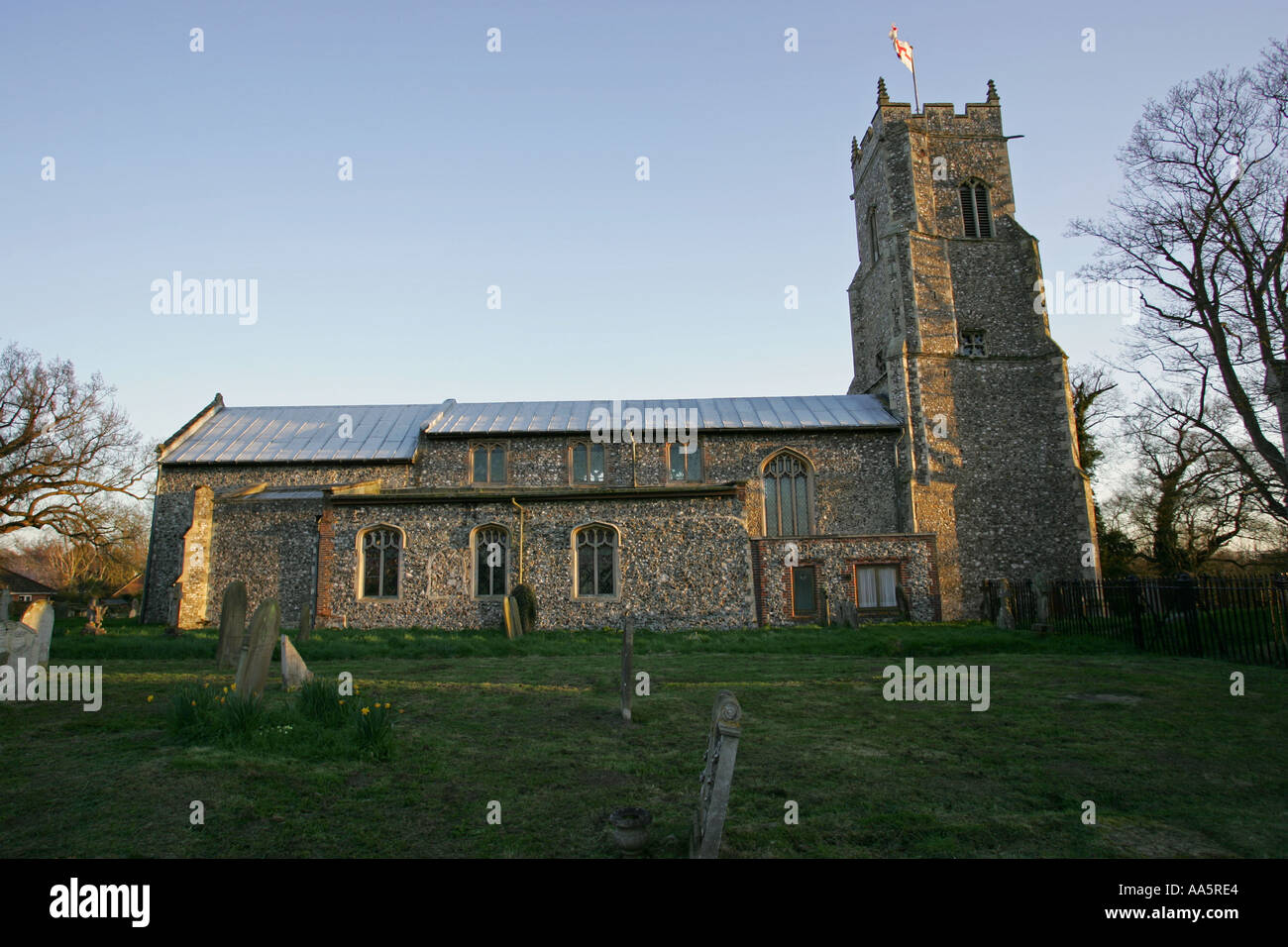 Typical Norman built English church and graveyard at sunset Norfolk ...