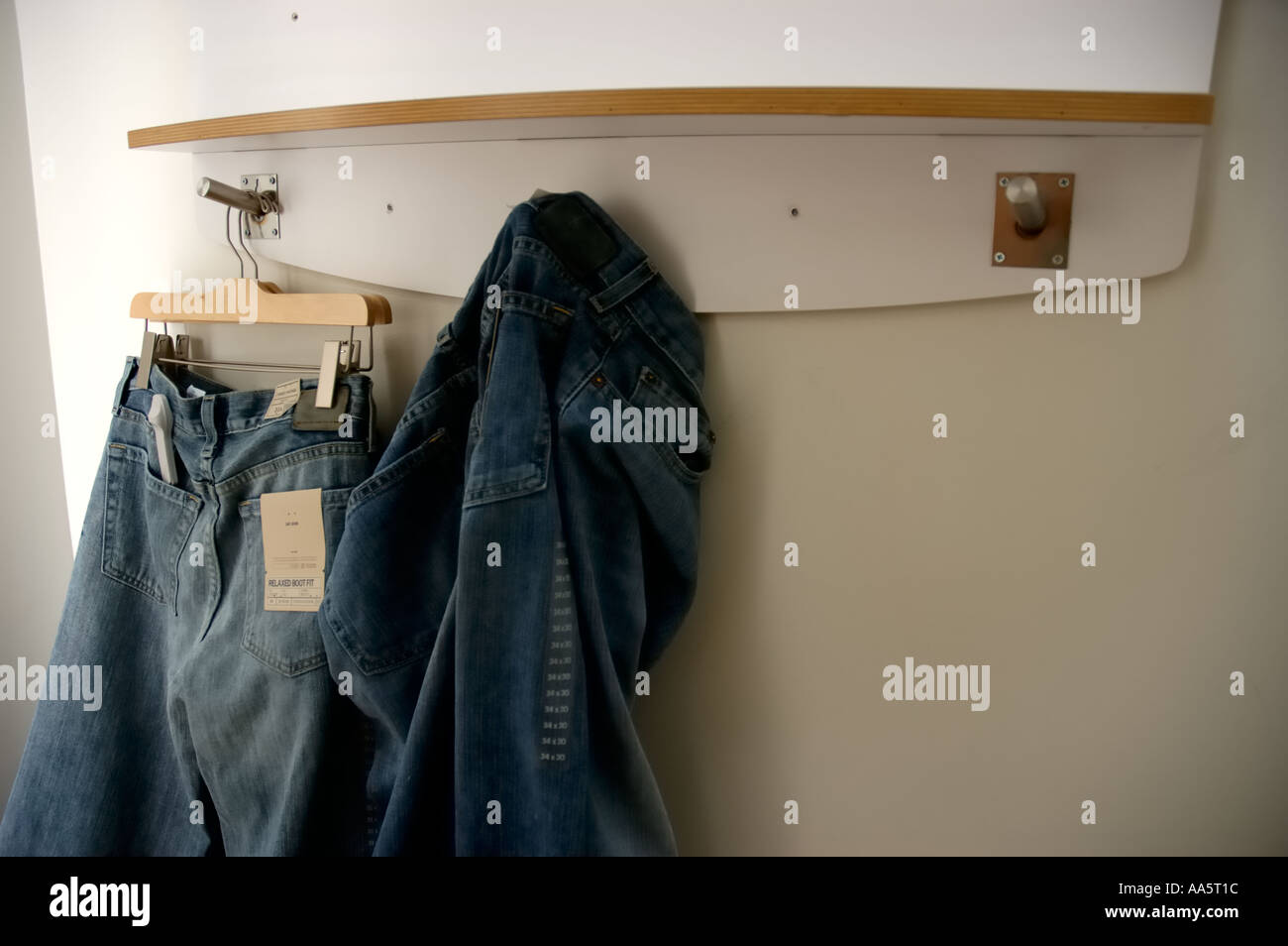 Two jeans on hangers in fitting room Stock Photo - Alamy