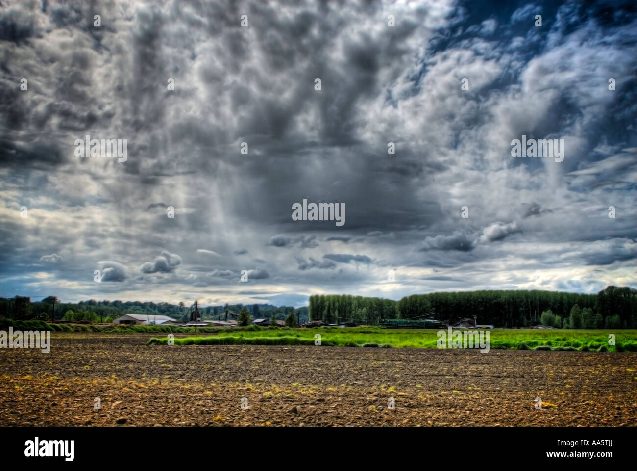 HDR image of a farm and field under a dramatic cloudy sky Stock Photo ...