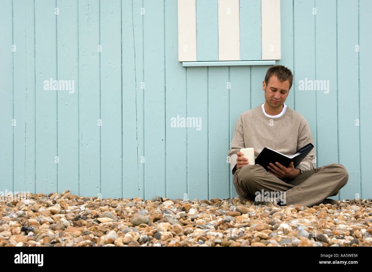 man studying sitting on a beach Stock Photo - Alamy