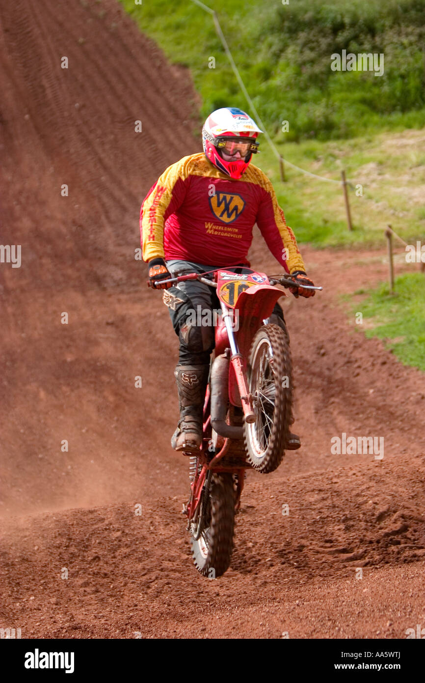 A motocross rider takes a jump on his machine on a circuit of the ...