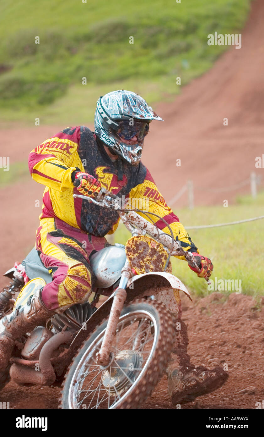 A motrocyclist in a motoX race going through with mud splatters over ...