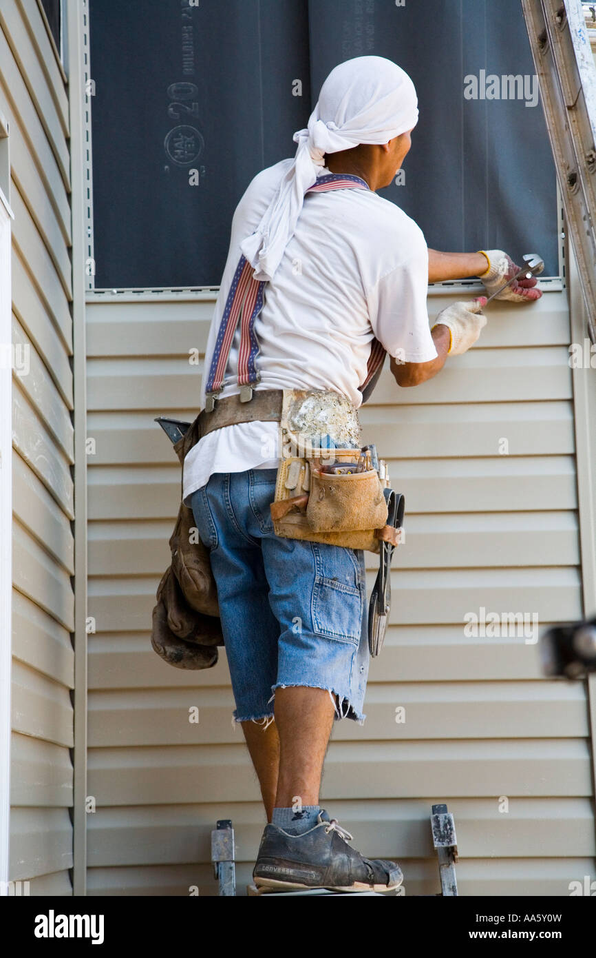 Immigrant Workers Installing vinyl Siding Stock Photo - Alamy