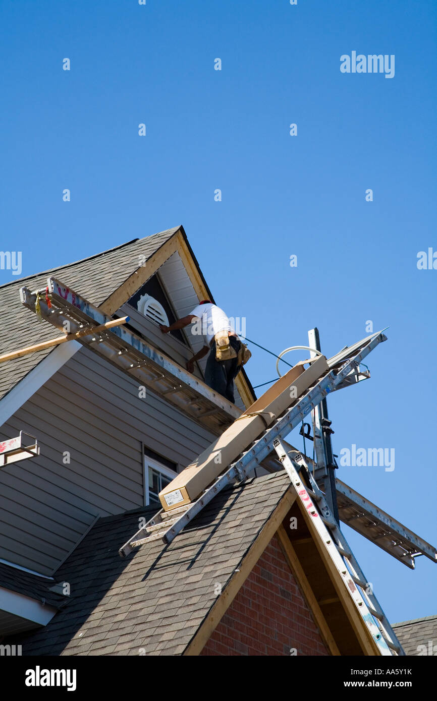 Immigrant Workers Installing vinyl Siding Stock Photo - Alamy