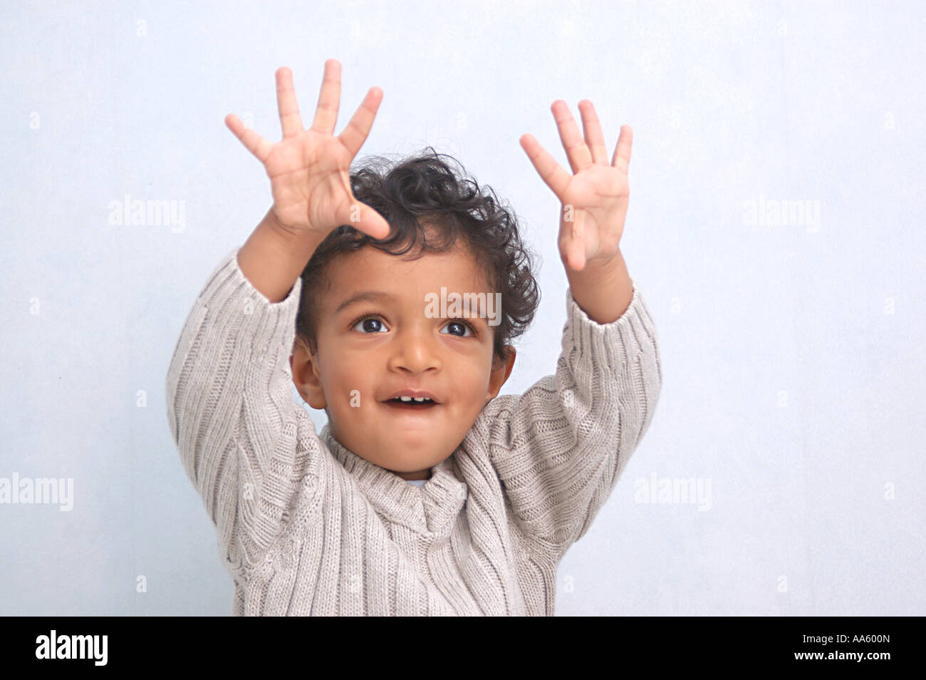 Small Indian boy of two and half years naughty and smiling hands raised ...