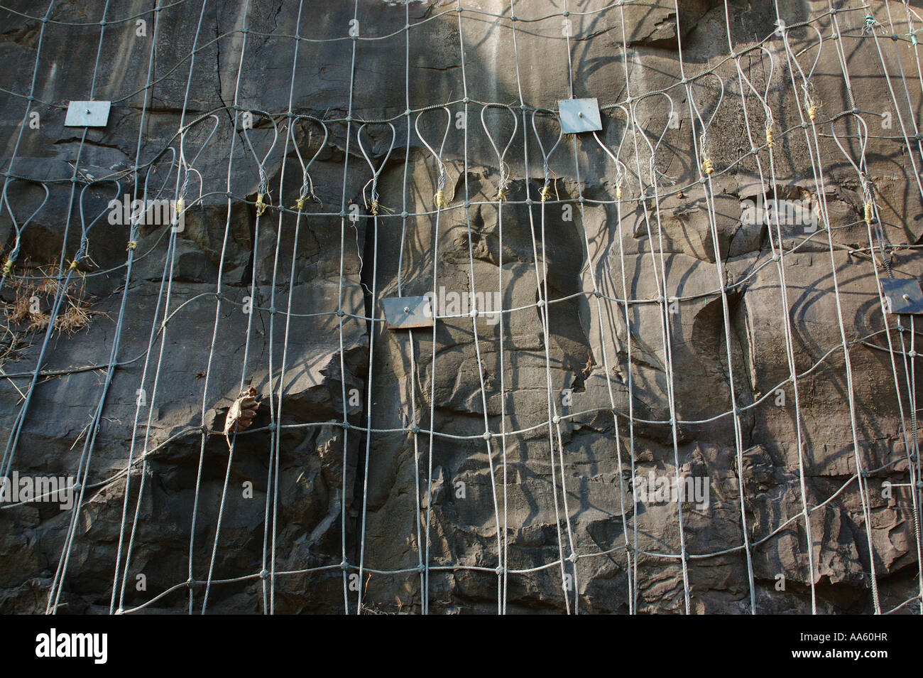 Steel wire net nailed in rocks to hold landslide loose rocks of the ...