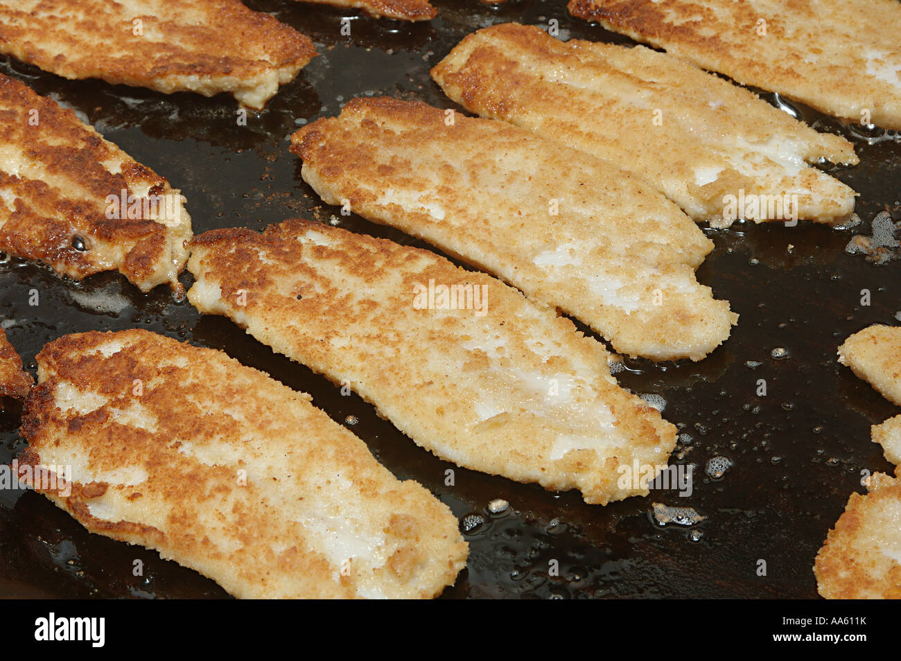 Frying fish on large electrical hot plate Stock Photo - Alamy
