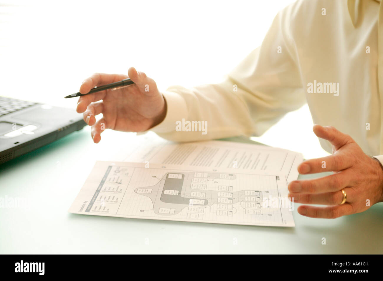 Close up of laptop computer desktop paperwork and hands with white ...