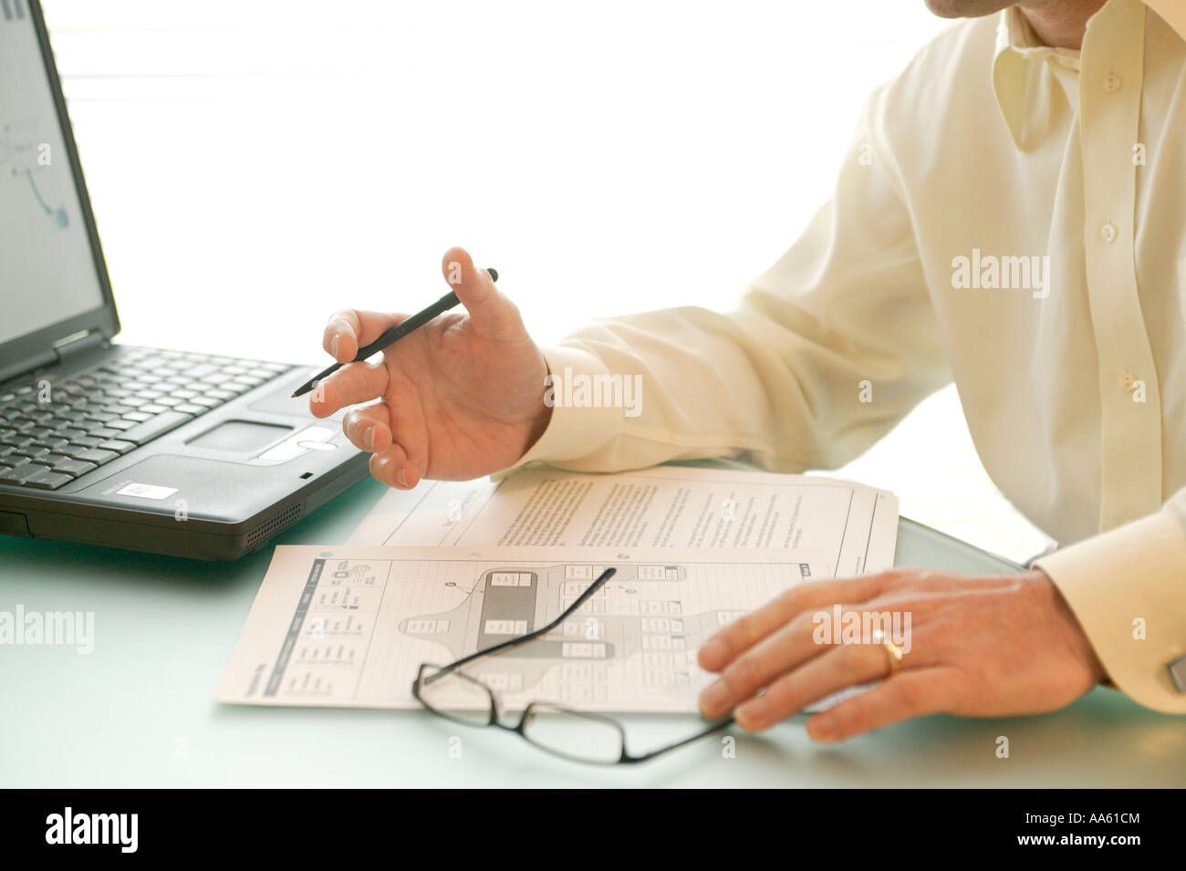 Close up of [laptop computer] desktop paperwork and hands with white ...