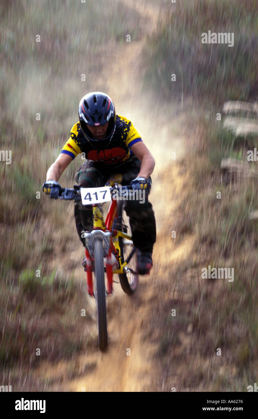 Downhill Mountain Bike Racer racing down a steep hill leaving a trail ...