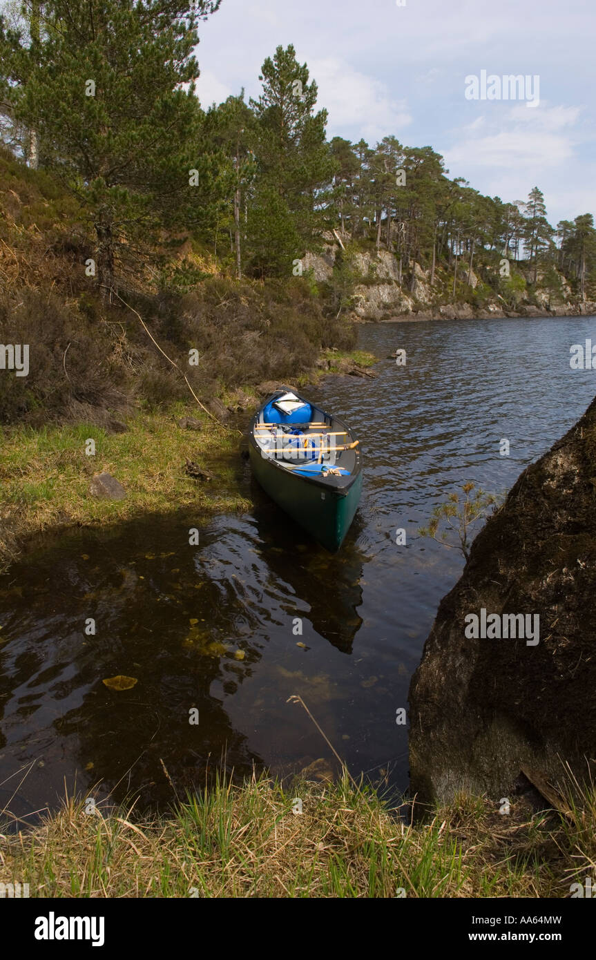 A canoe tied up on an island on a loch in Glen Affric Scotland Stock ...
