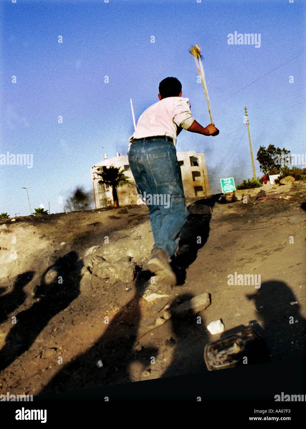 A Palestinian throws a rock at Israeli soldiers in the West Bank town ...