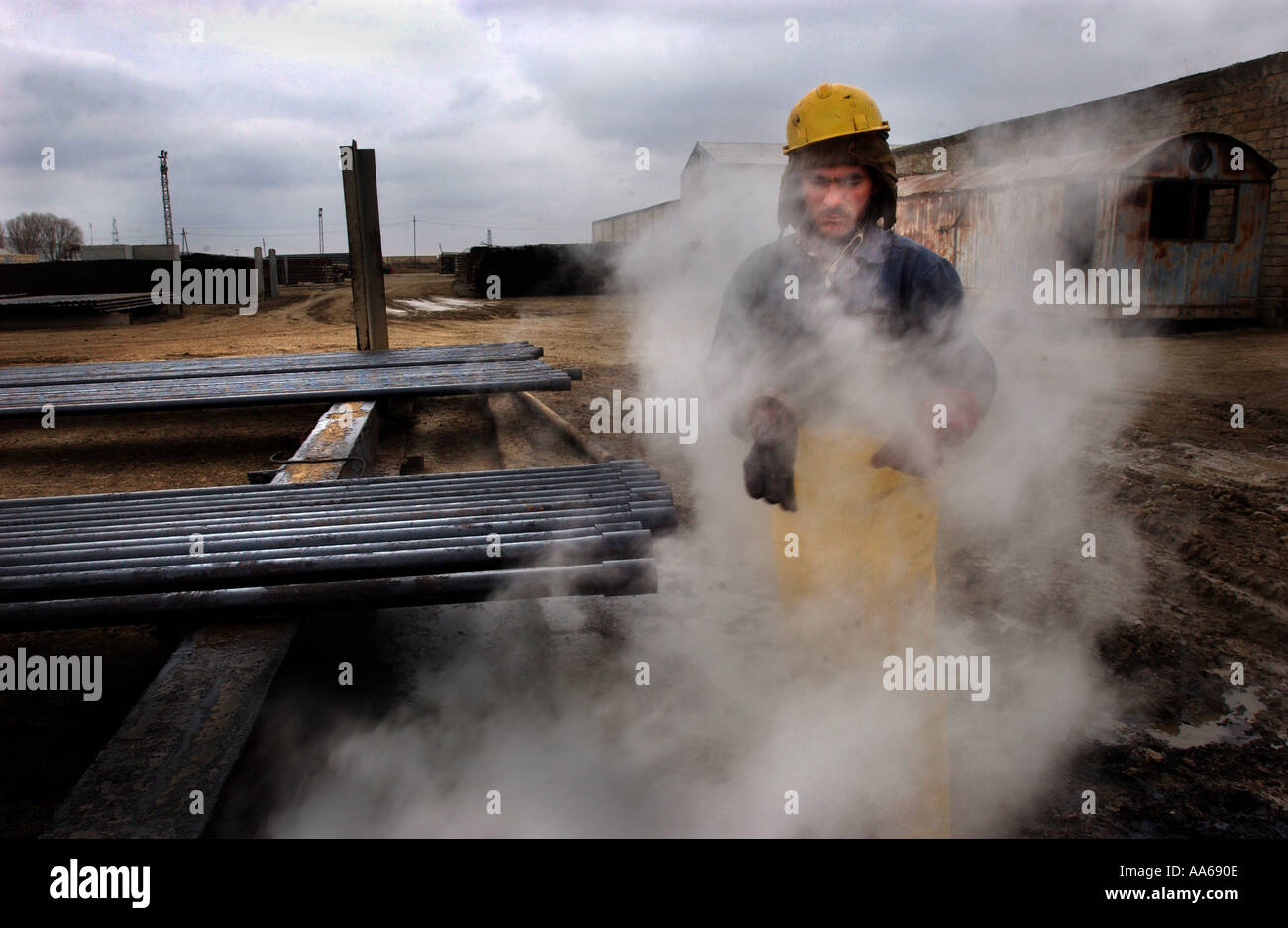 An oil worker cleans pipes on an oil field in the Caspian Sea near Baku ...