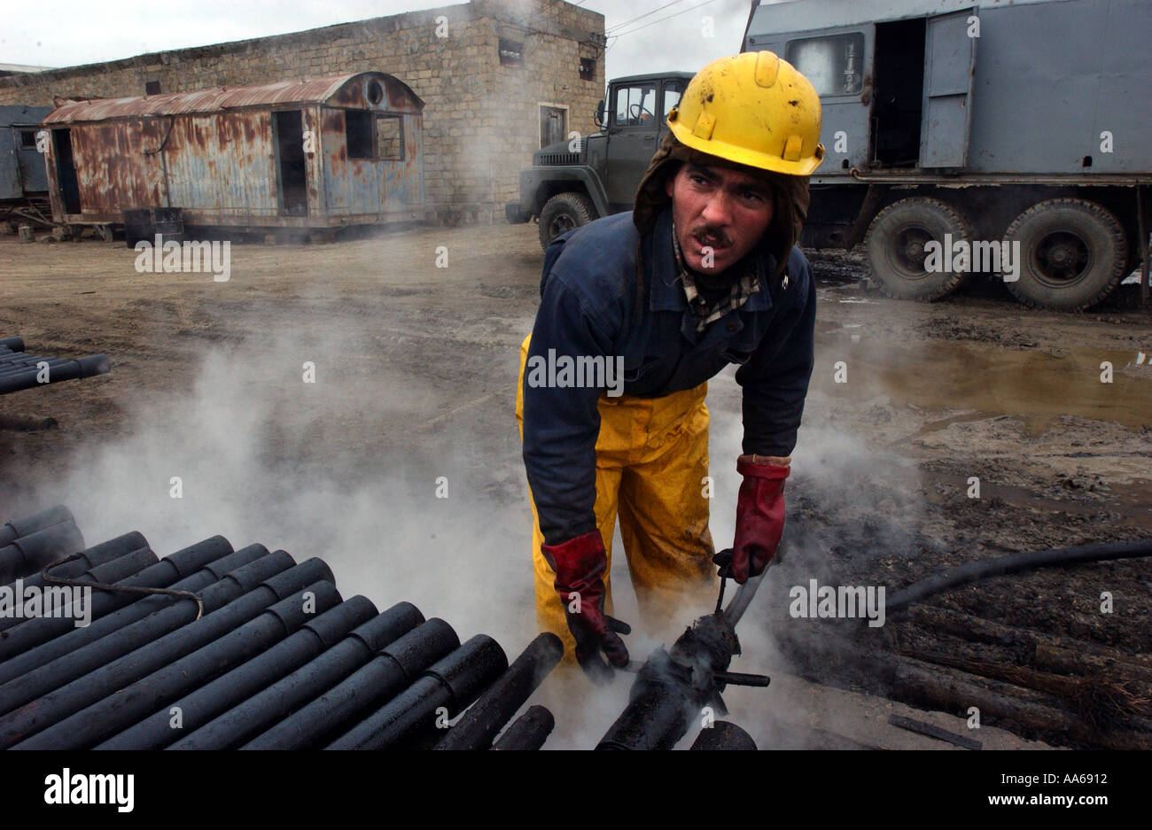 An oil worker cleans pipes on an oil field in the Caspian Sea near Baku ...