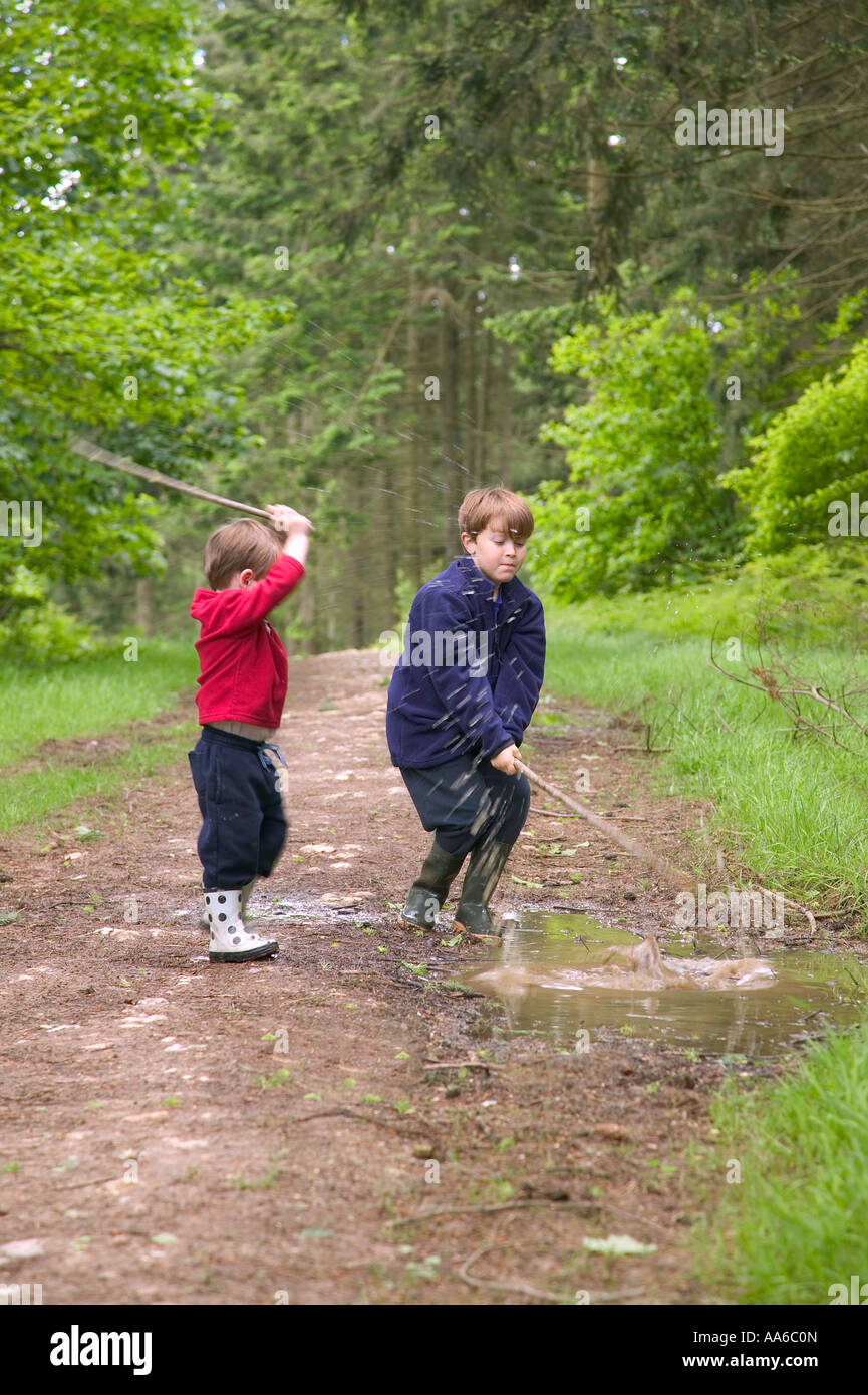 Two young brothers having fun splashing in a muddy puddle Stock Photo ...