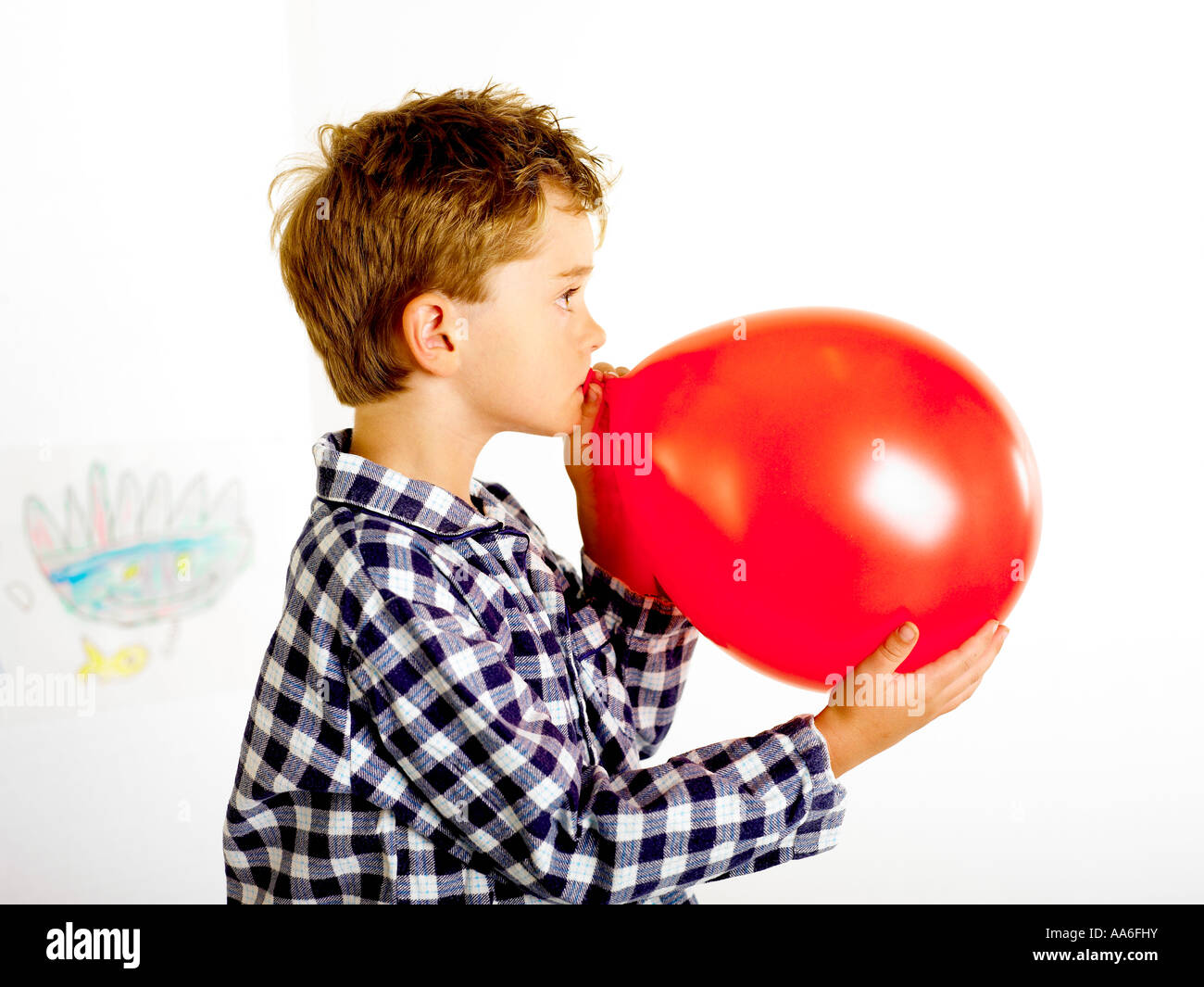 Boy blowing up red balloon hi-res stock photography and images - Alamy
