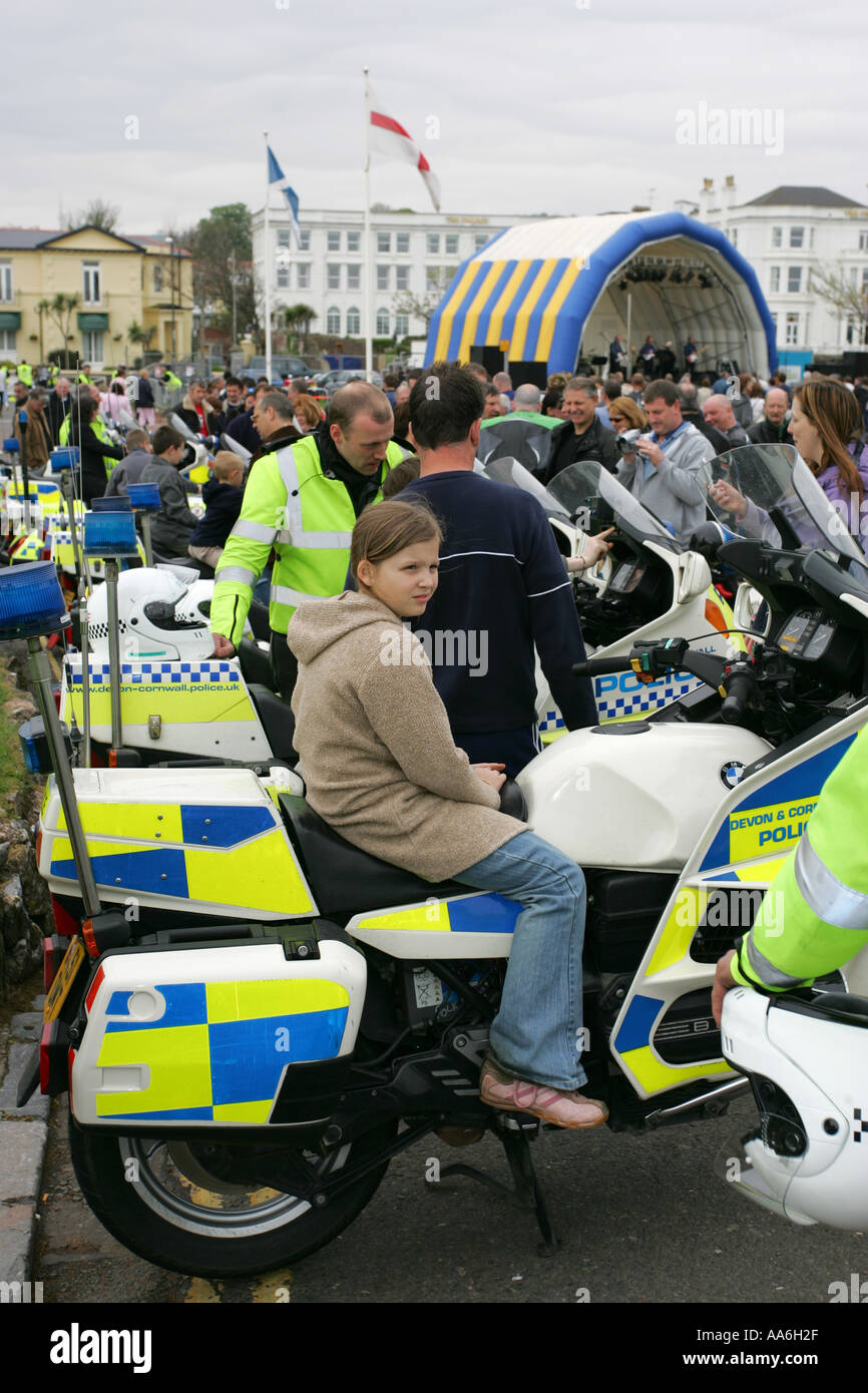 A young teenage girl sits on a police motorbike at a bikers festival in ...
