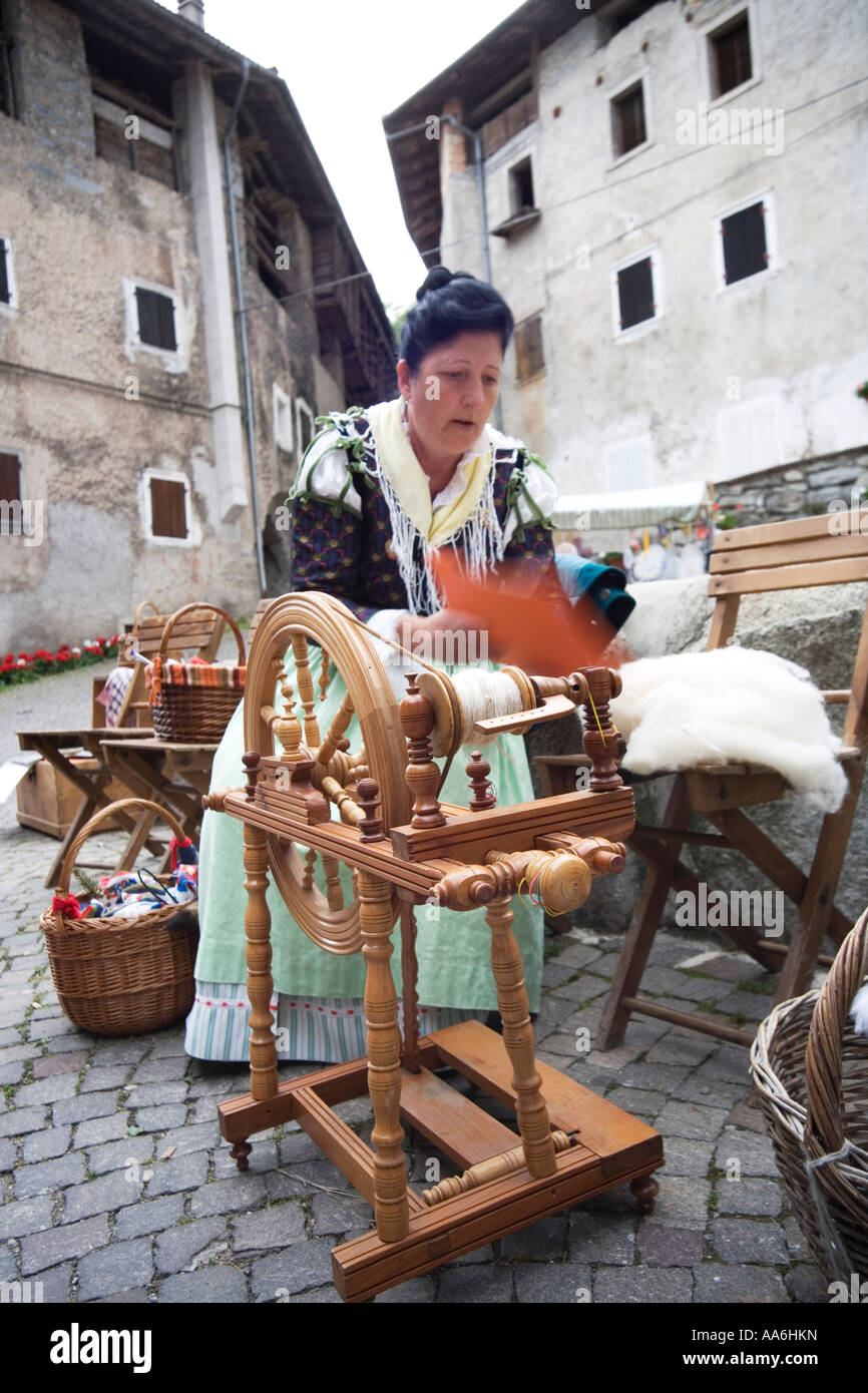 Woman in traditional costumes showing the old art of producing wool ...