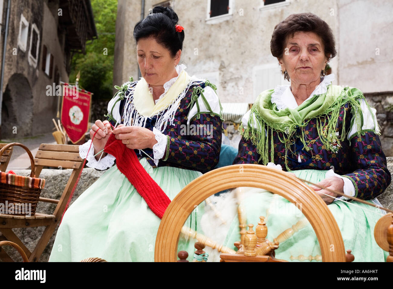 Women in traditional costumes showing the old art of producing wool ...