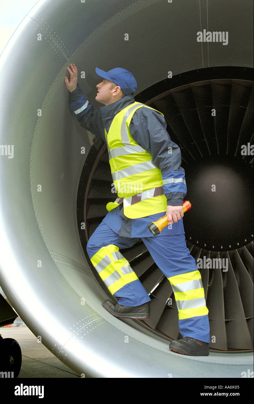 An engineer wearing protective clothing is standing inside the engine ...