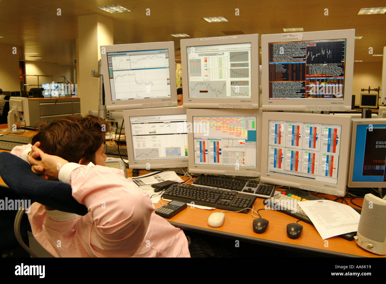 A city dealer is leaning back casually and looking at information on ...