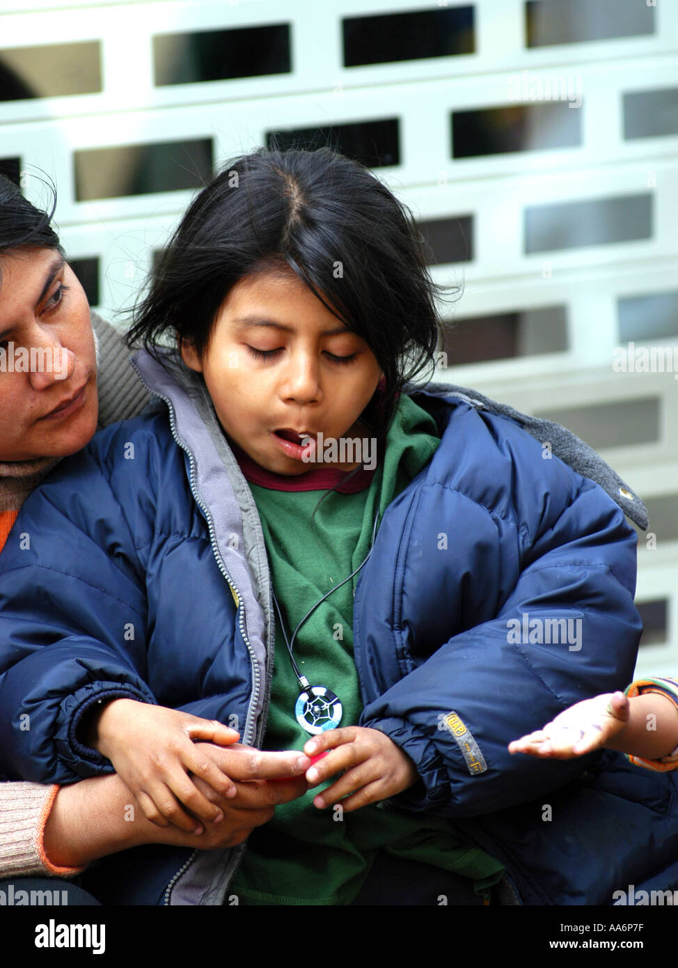Homeless Mexican mother with her boy sitting on the side of the street ...