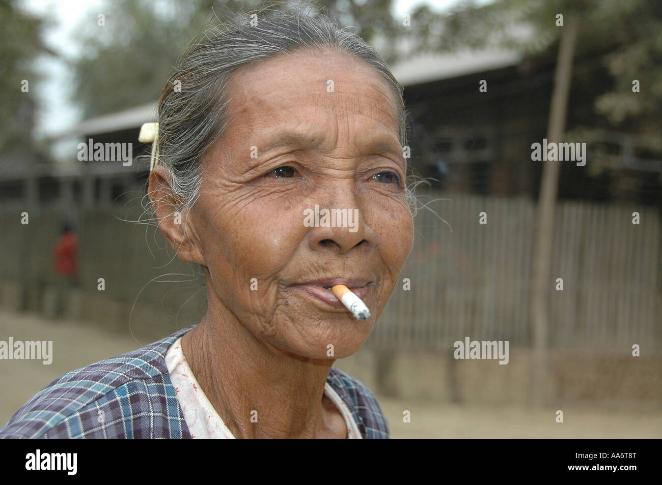 Myanmar Mandalay A female Villager smoking a cigarette along the ...
