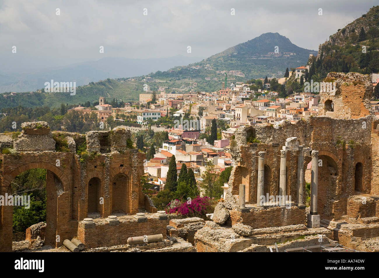 View of city of Taormina through broken walls of the Teatro Greco ...