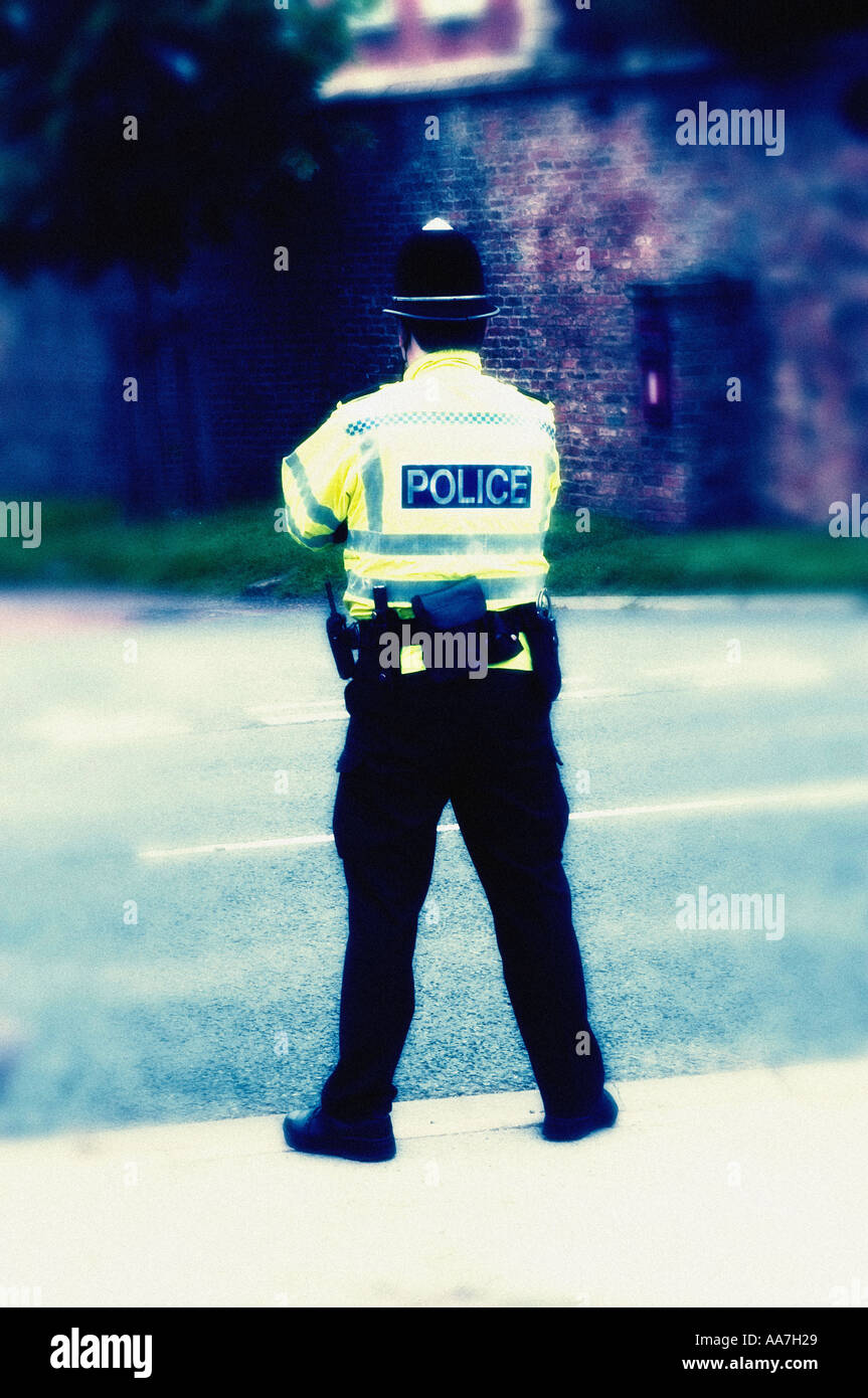 On-duty police officer standing with back to the camera in a powerful ...