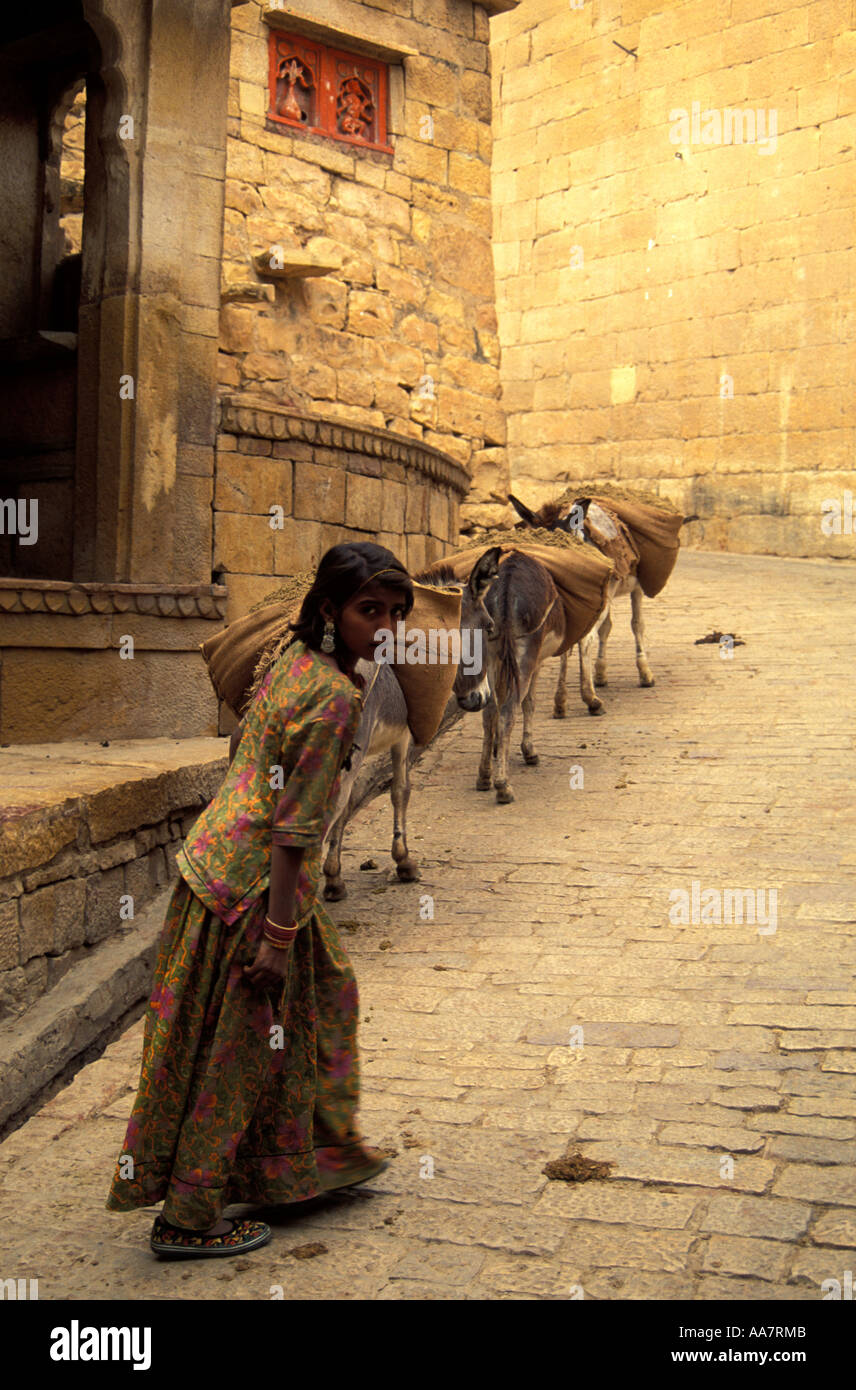 Young female Indian donkey herder following animals into Jaisalmer Fort ...